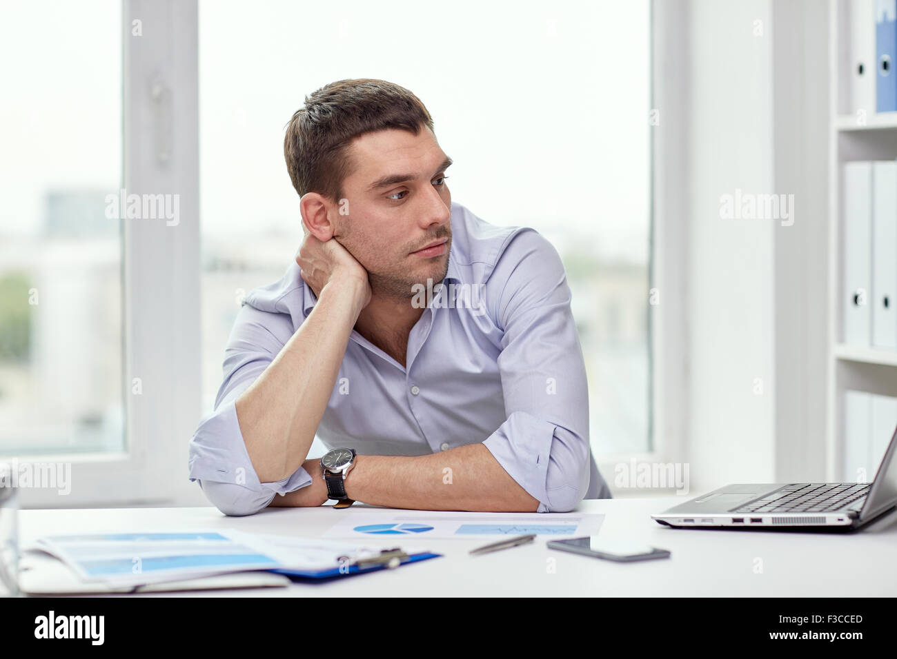 bored businessman with laptop and papers at office Stock Photo - Alamy