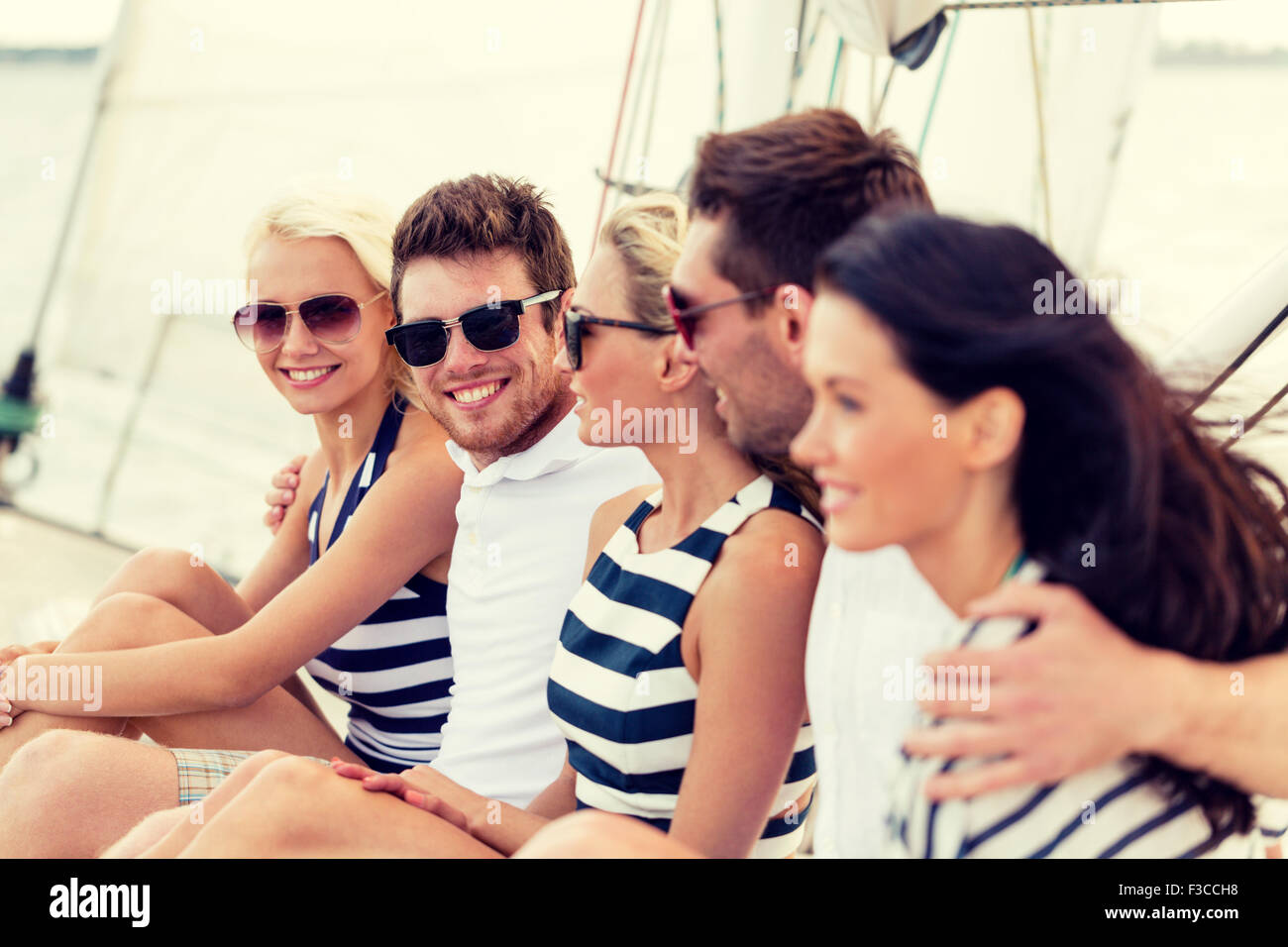 smiling friends sitting on yacht deck Stock Photo - Alamy