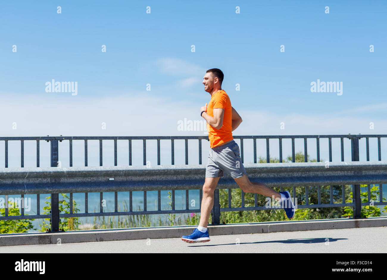 smiling young man running at summer seaside Stock Photo - Alamy