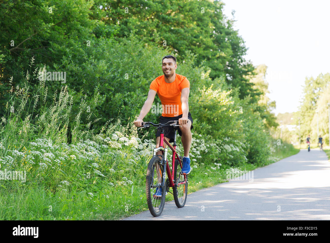 happy young man riding bicycle outdoors Stock Photo - Alamy