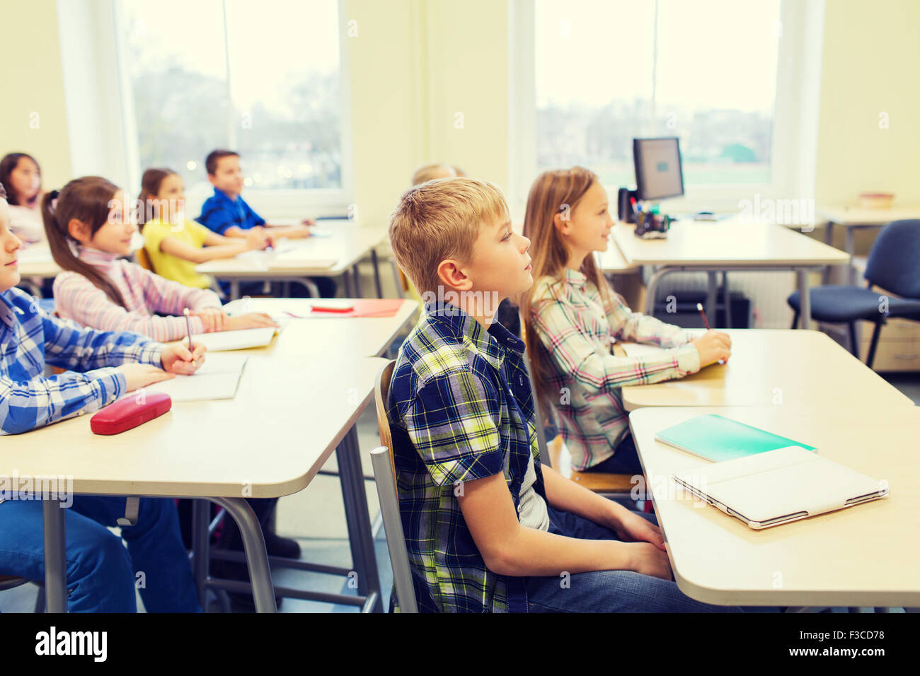 group of school kids with notebooks in classroom Stock Photo - Alamy