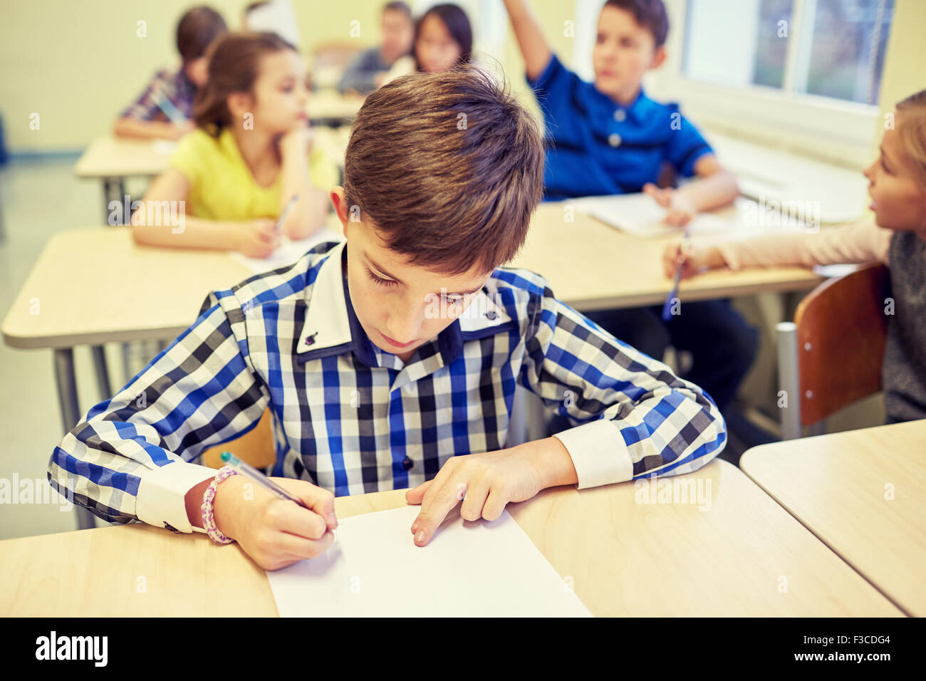 group of school kids writing test in classroom Stock Photo - Alamy