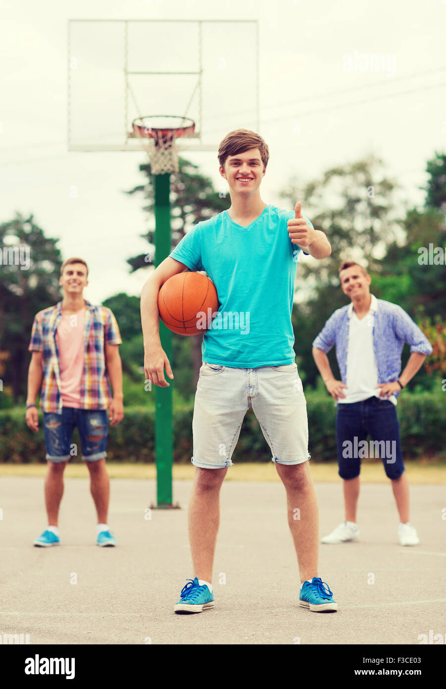 group of smiling teenagers playing basketball Stock Photo - Alamy