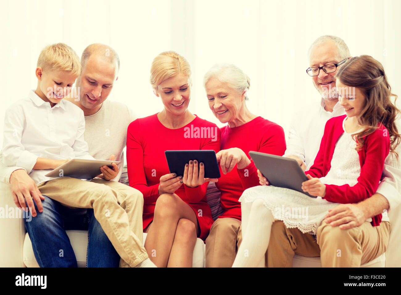 smiling family with tablet pc computers at home Stock Photo - Alamy