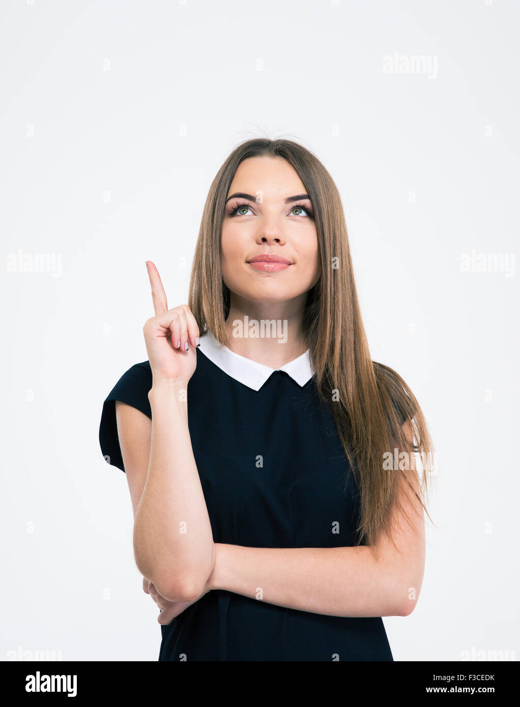 Portrait of a pretty thoughtful woman pointing finger up at copyspace ...