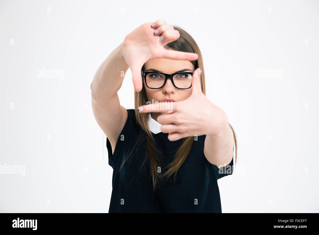 Portrait of a young woman making frame with fingers isolated on a white ...