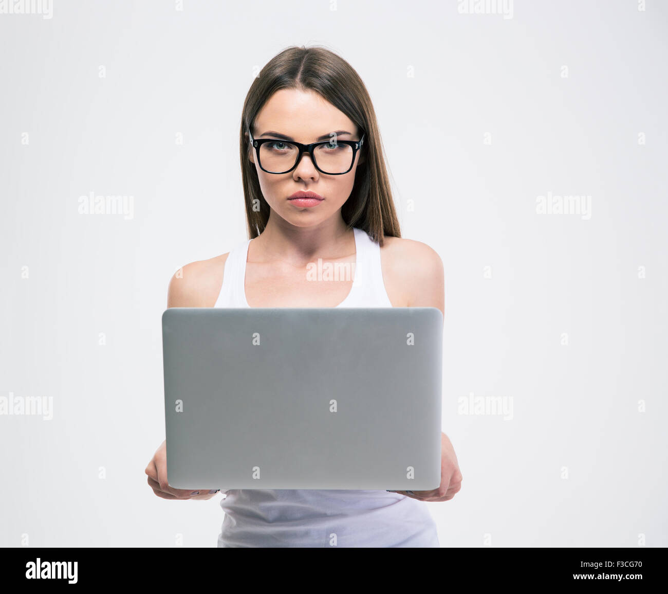 Portrait of a cute female student standing with laptop isolated on a ...