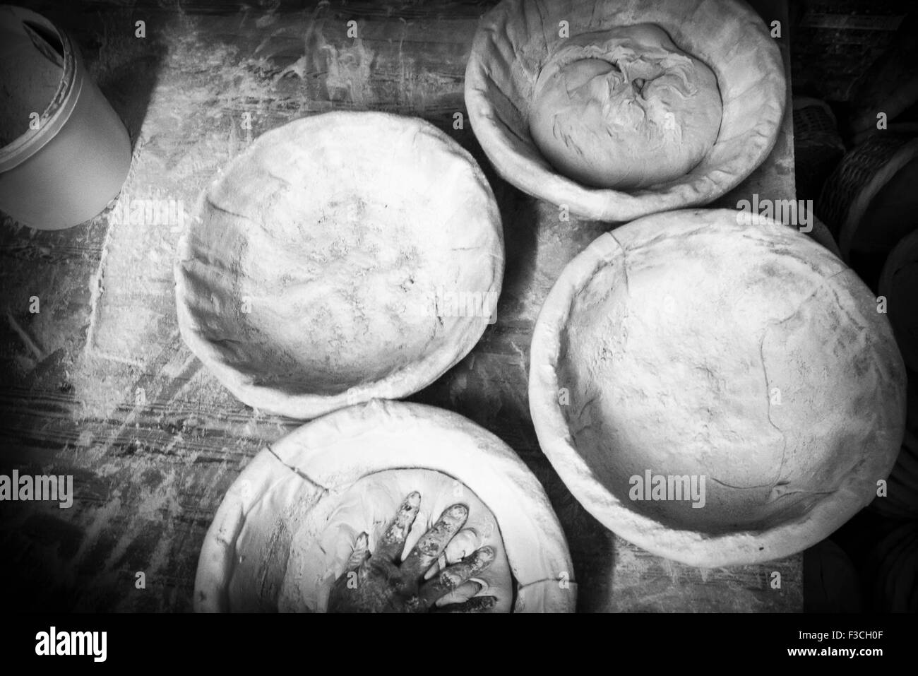 Baker placing dough in baskets for proofing Stock Photo - Alamy
