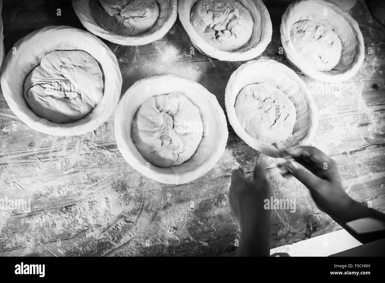 Baker placing dough in baskets for proofing Stock Photo - Alamy