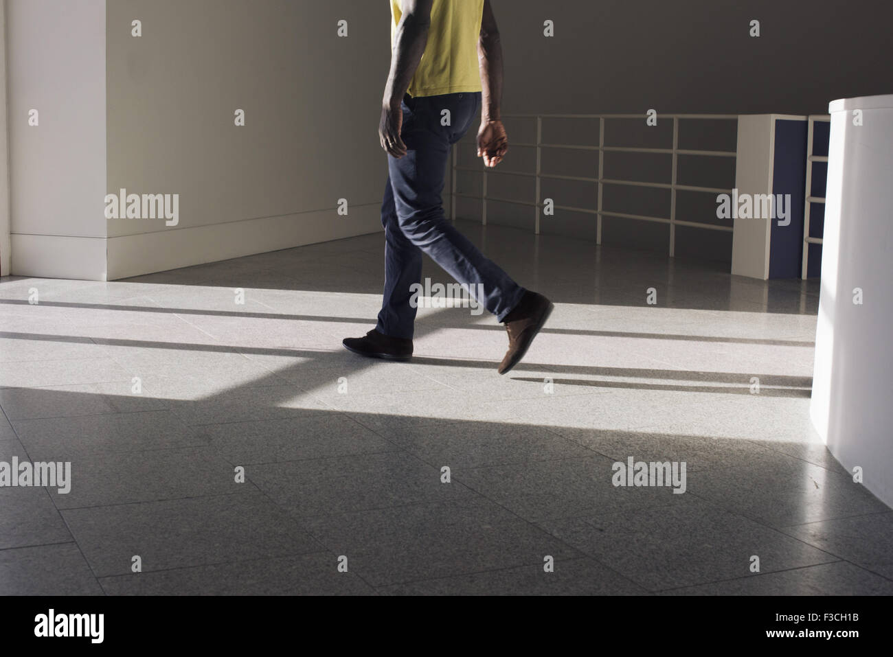 Man walking along building hallway, low section Stock Photo - Alamy