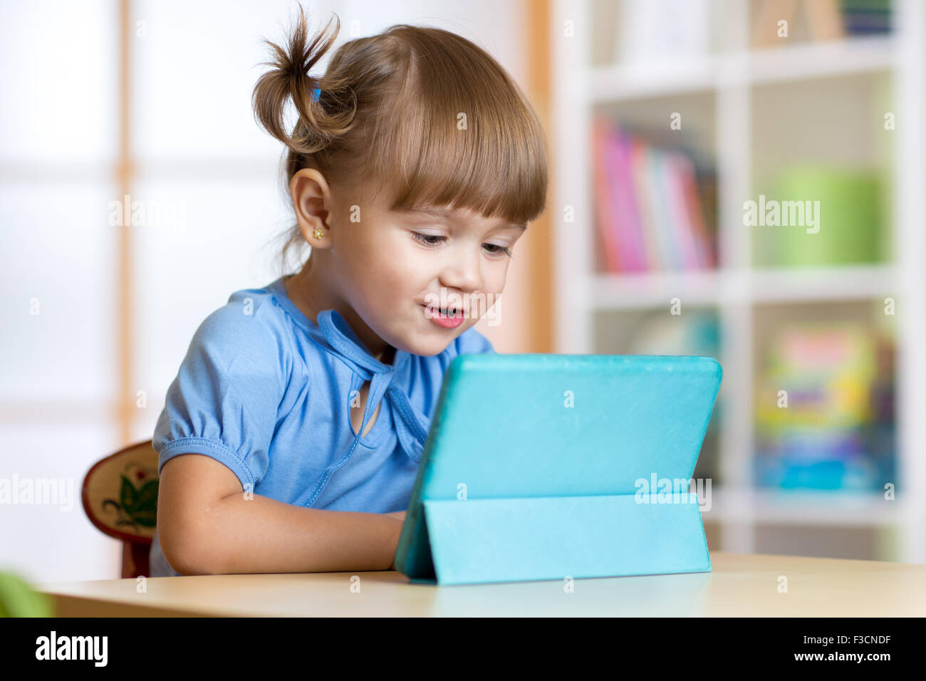 kid girl playing with tablet computer at home Stock Photo - Alamy