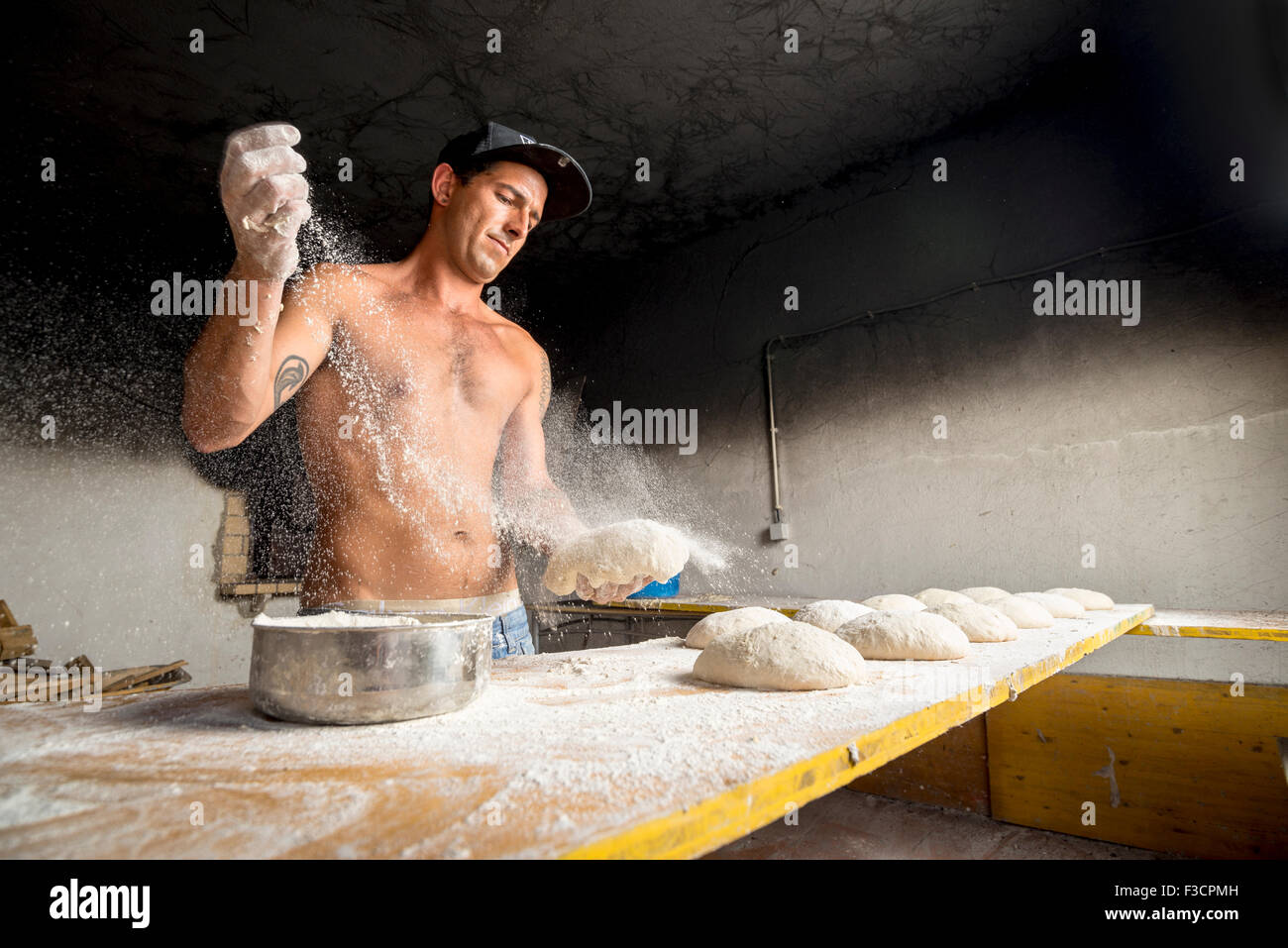 Young baker making bread by hand in traditional brick oven Stock Photo ...