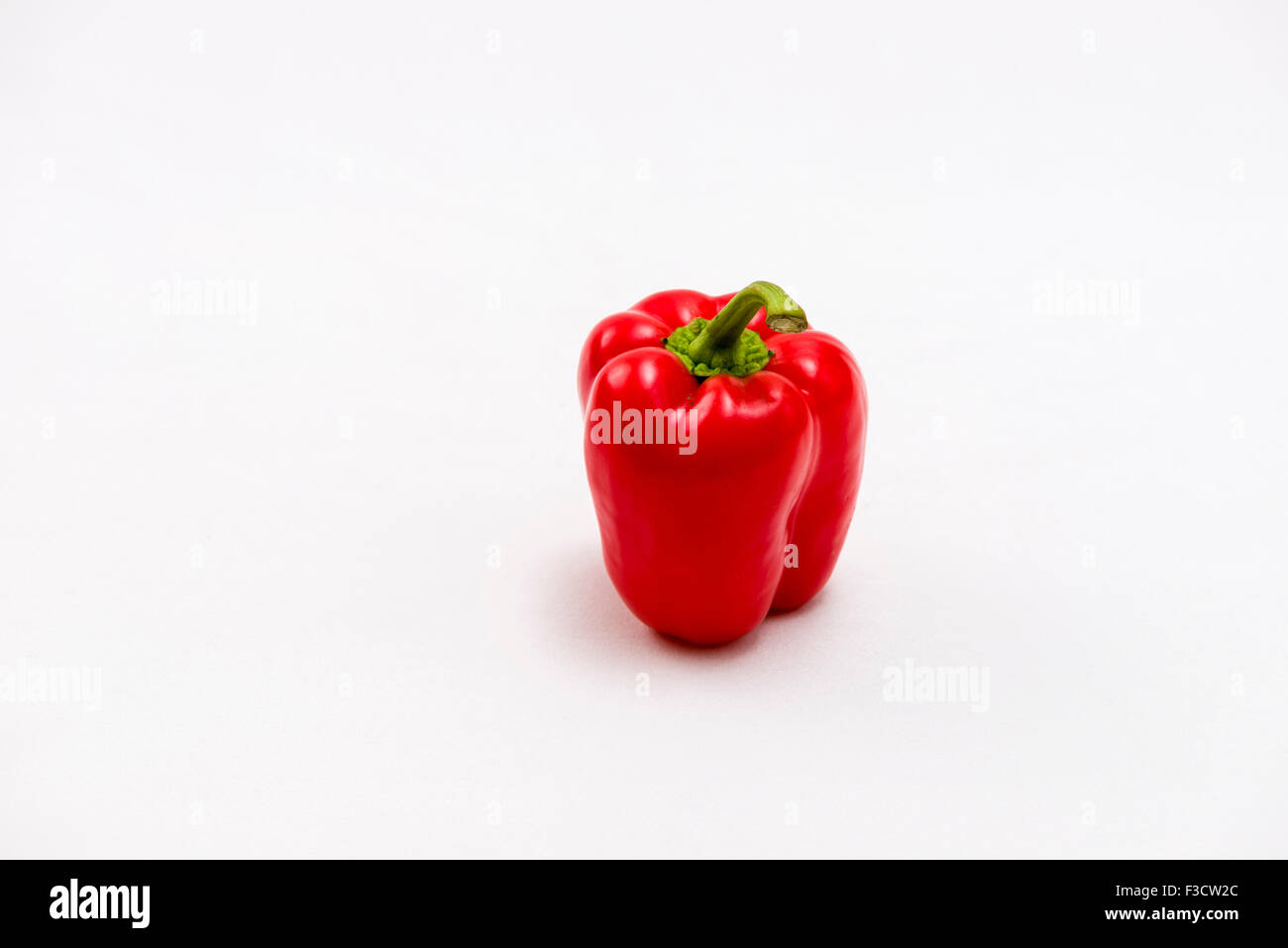 A red capsicum (Capsicum annuum), displayed on a white table Stock ...