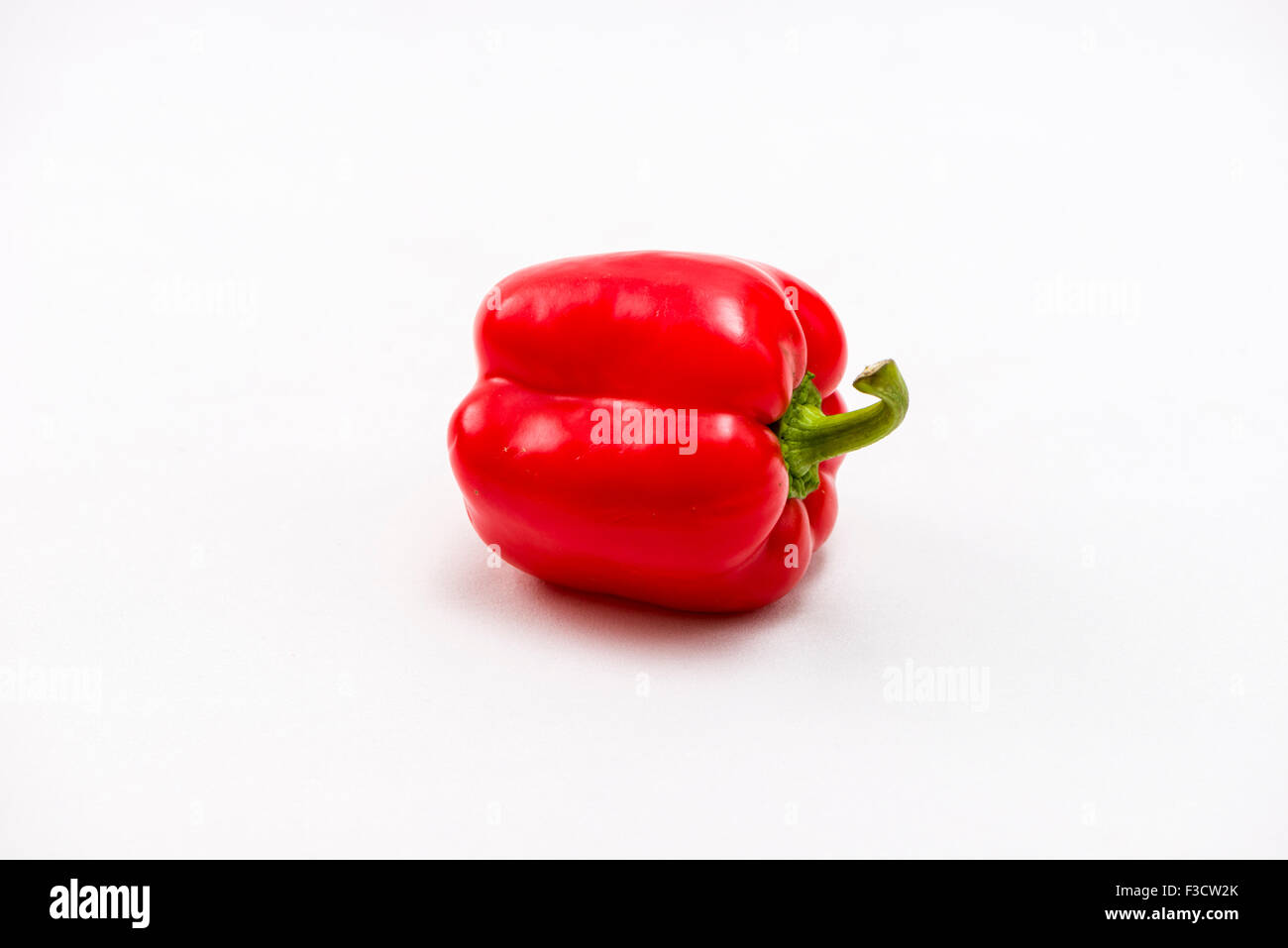 A red capsicum (Capsicum annuum), displayed on a white table Stock ...