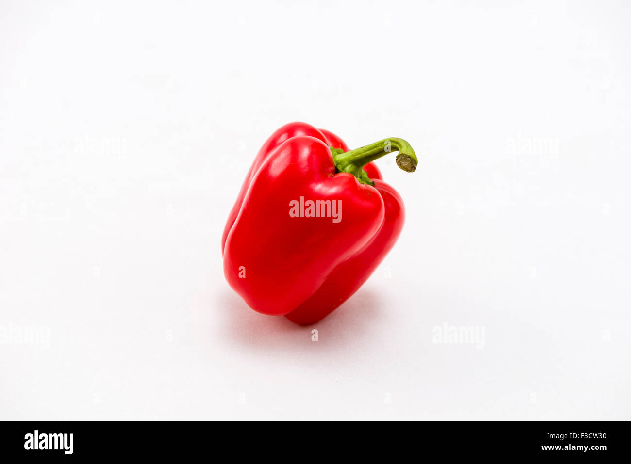 A red capsicum (Capsicum annuum), displayed on a white table Stock ...