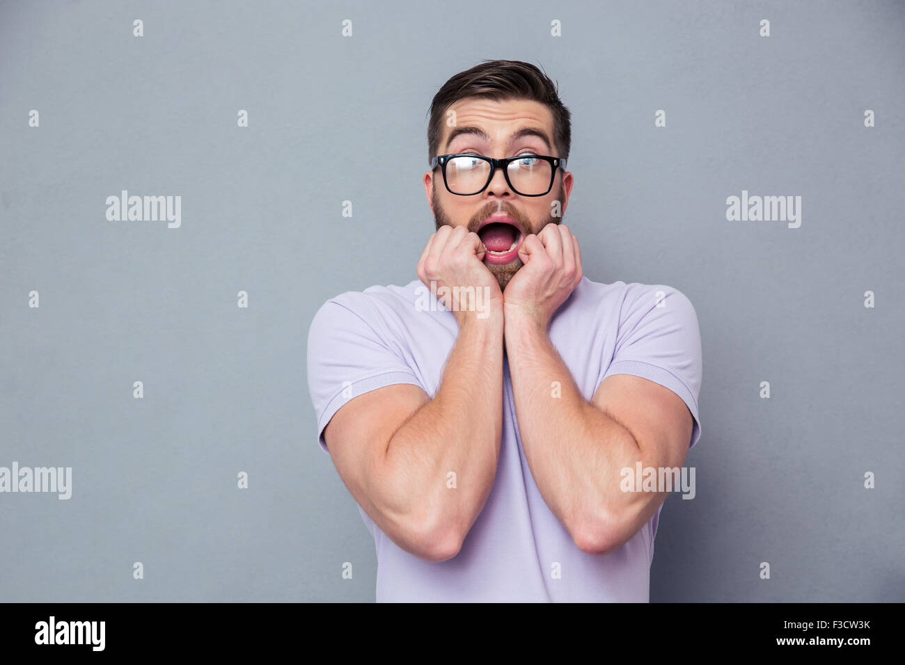 Portrait of a scared man looking at camera over gray background Stock ...