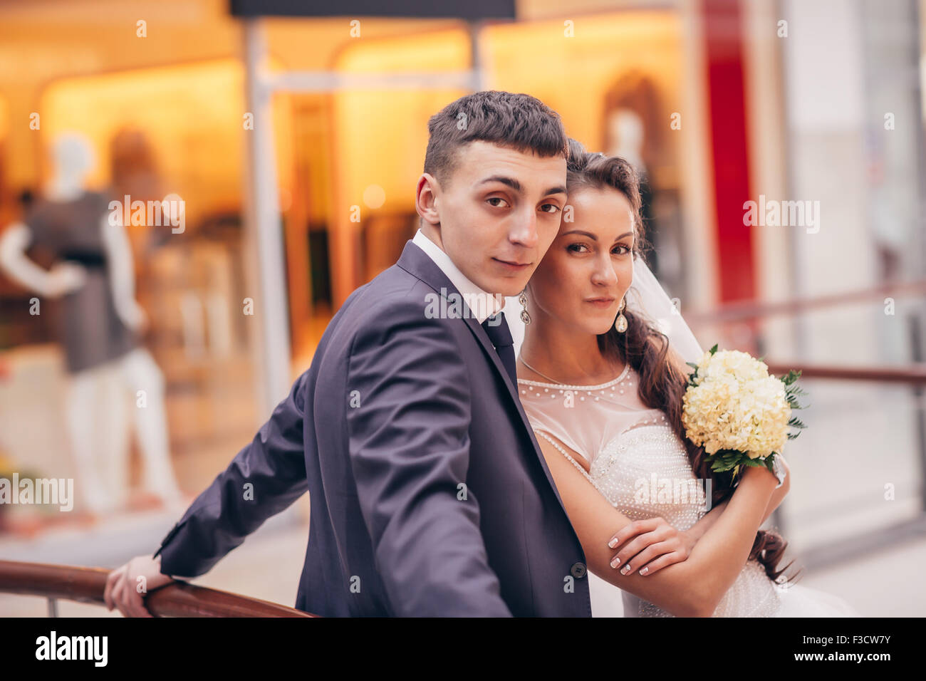 Happy bride and groom embracing in the spacious hall of the shopping ...