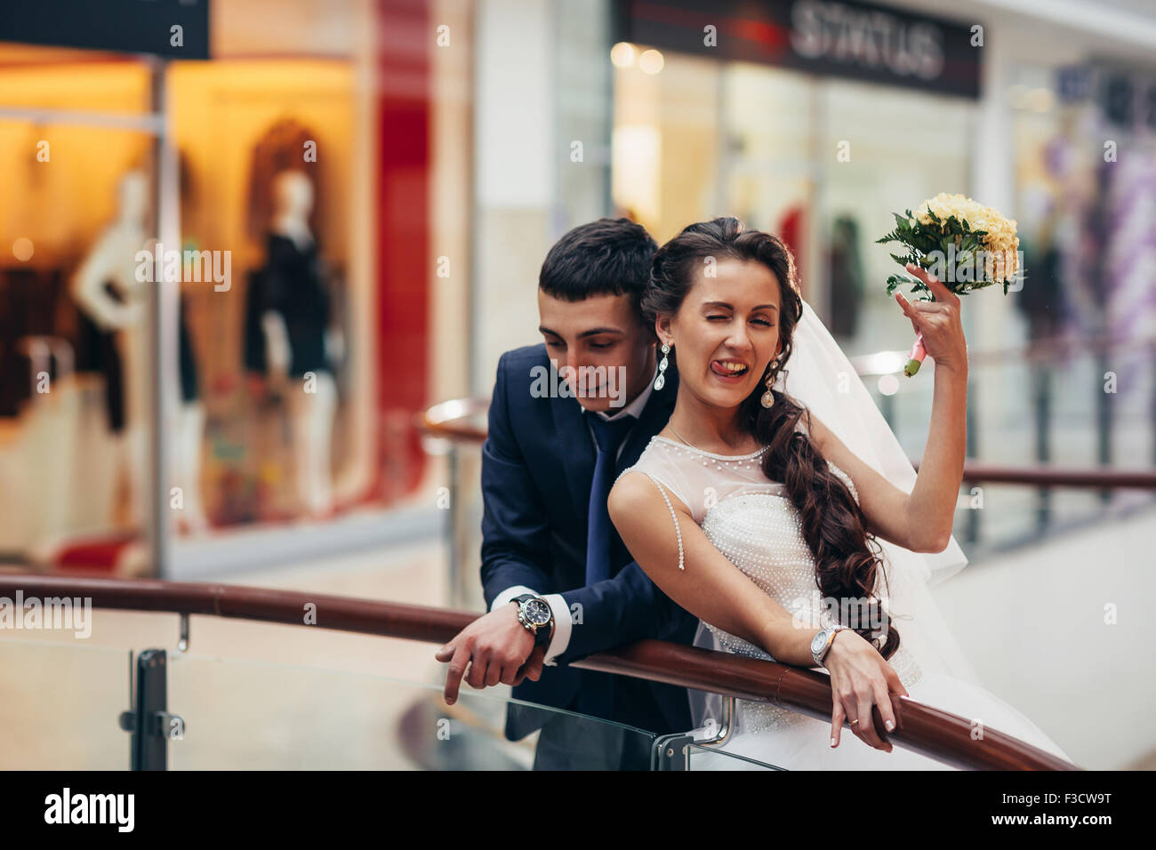 Happy bride and groom embracing in the spacious hall of the shopping ...