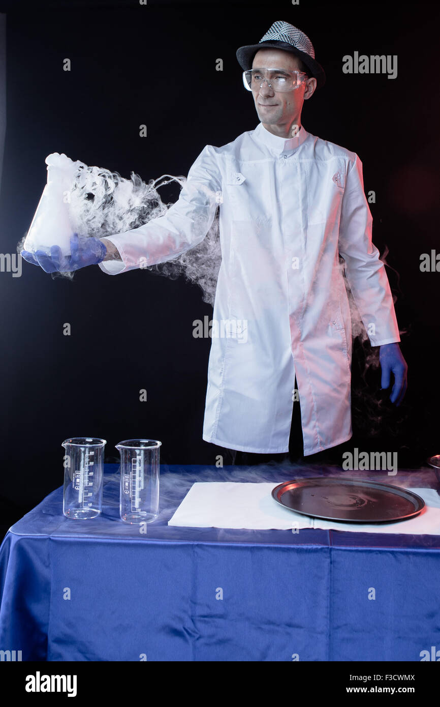 Smiling man scientist with dry ice Stock Photo - Alamy