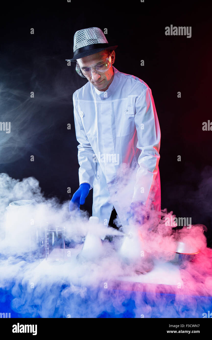 Smiling man scientist with dry ice Stock Photo - Alamy