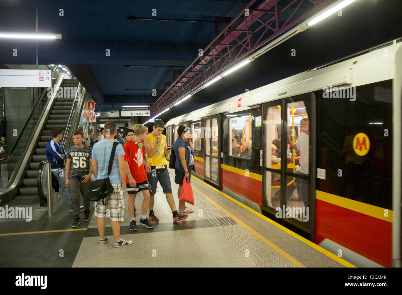 Poland Warsaw Metro station platform with passengers and arriving train ...