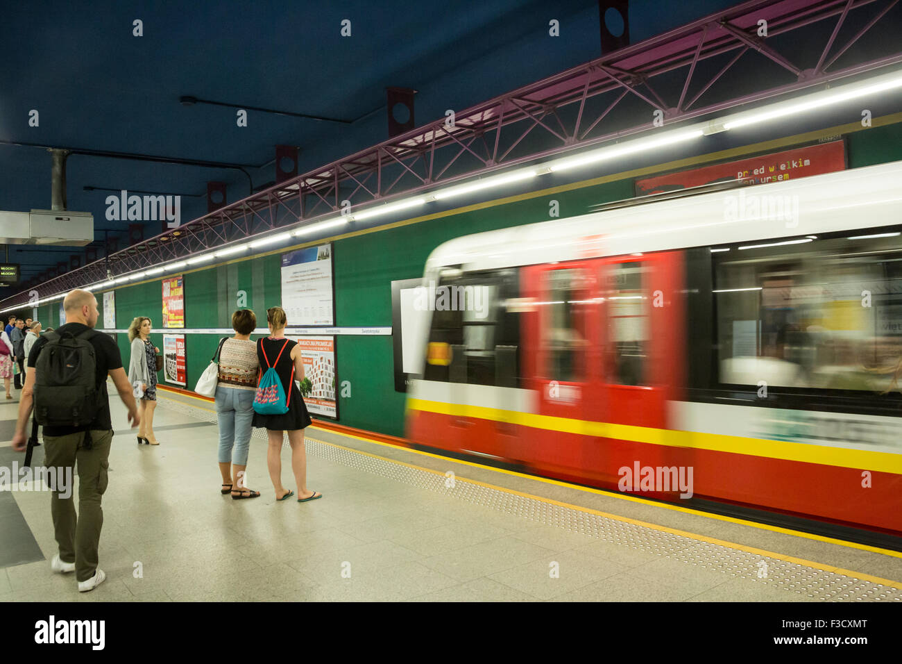 Poland Warsaw Metro station platform with passengers and arriving train ...
