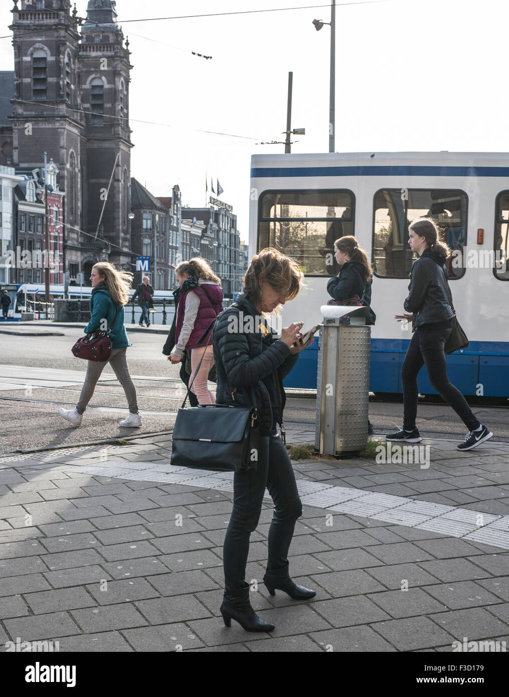 Random female pedestrian checking smartphone near Amsterdam Central ...