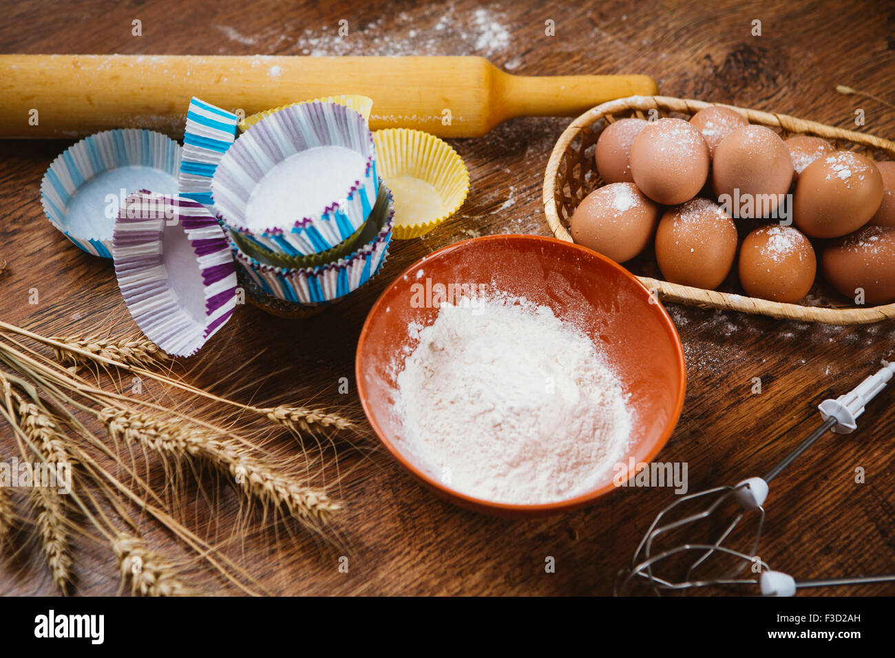 Colorful cupcake wrappers with baking pan on kitchen background Stock ...