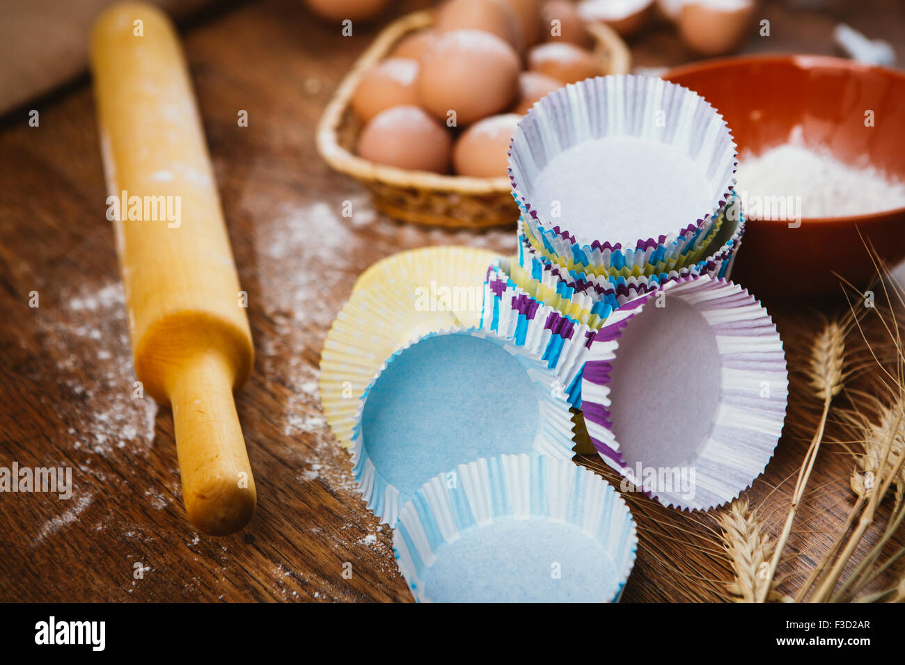 Colorful cupcake wrappers with baking pan on kitchen background Stock ...
