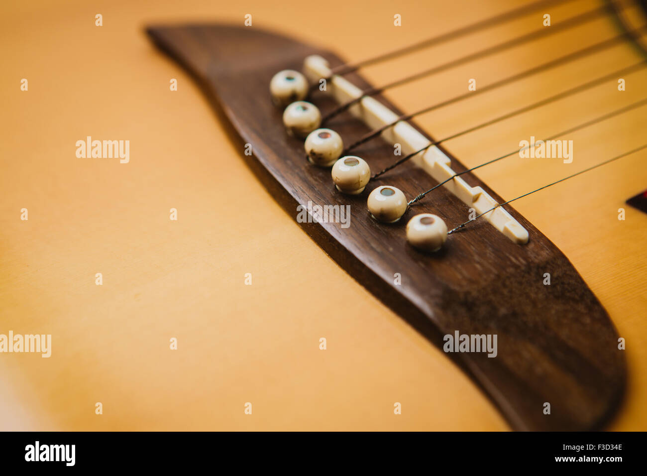 Macro shot down the fretboard of acoustic guitar with shallow depth of ...