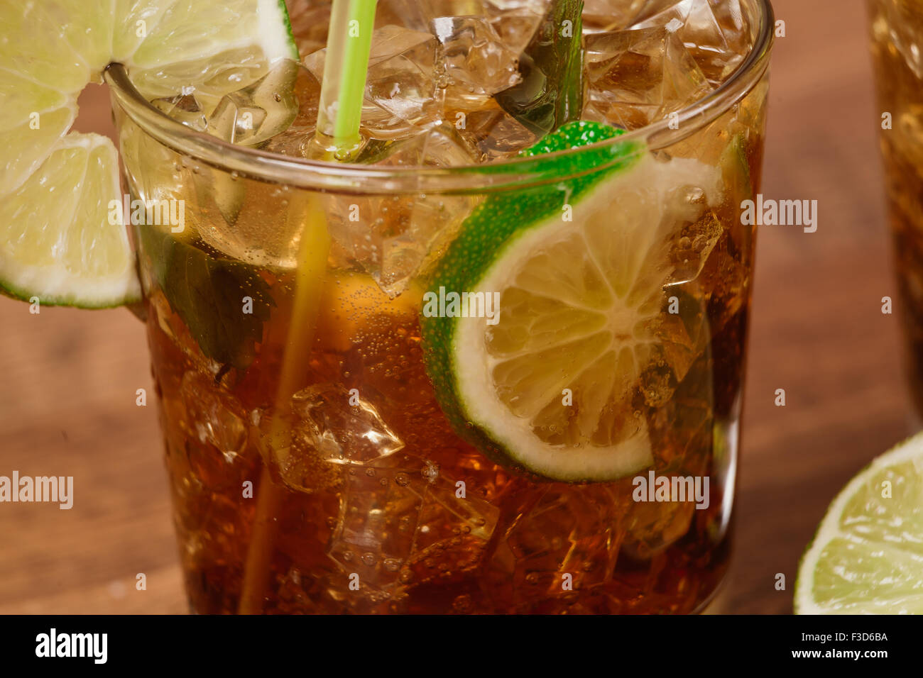 drink concept - cocktail with cola ice cubes and lime Stock Photo - Alamy