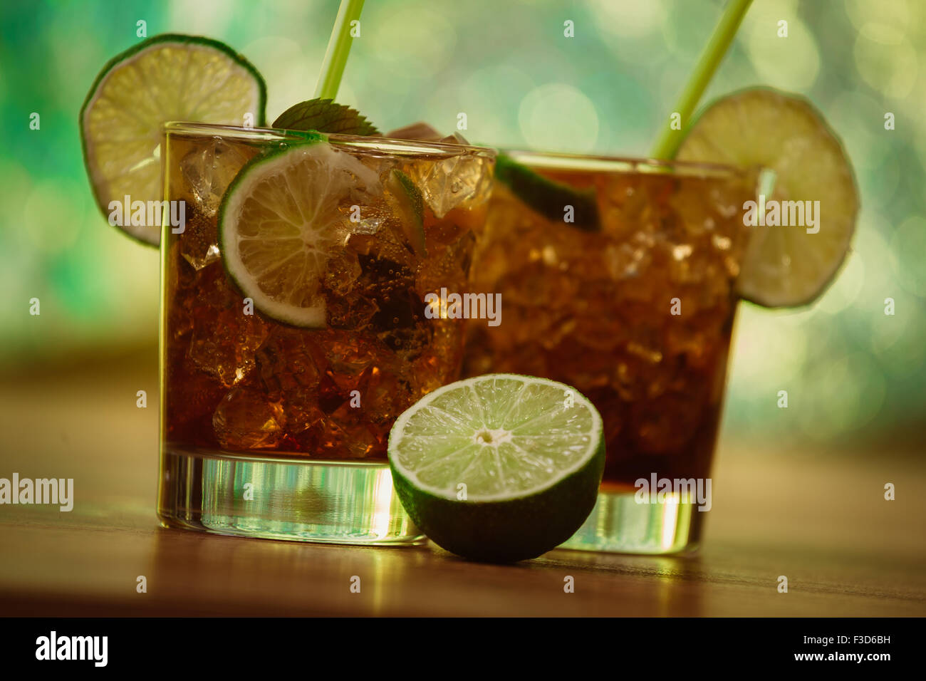drink concept - cocktail with cola ice cubes and lime Stock Photo - Alamy