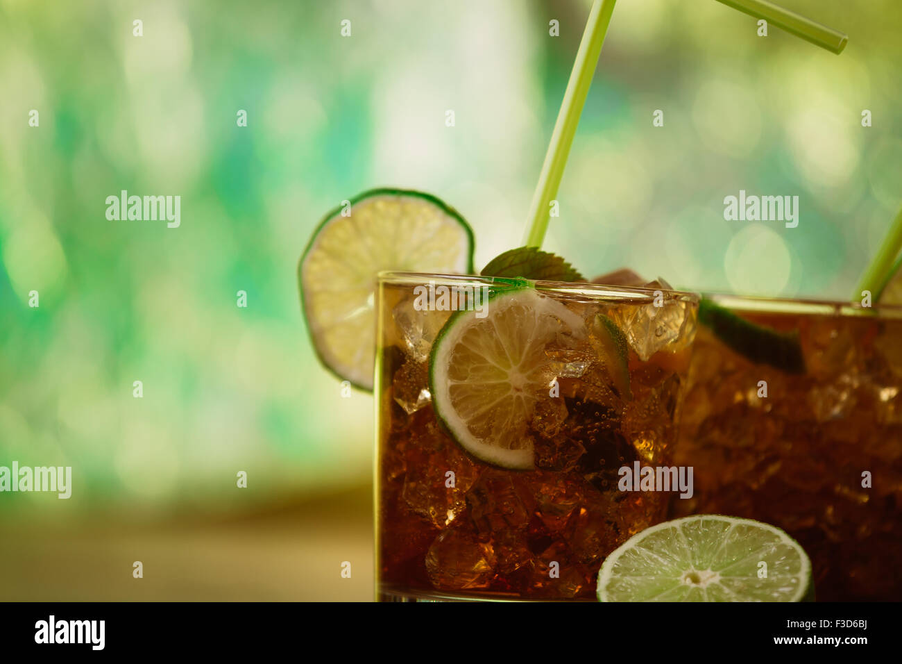 drink concept - cocktail with cola ice cubes and lime Stock Photo - Alamy