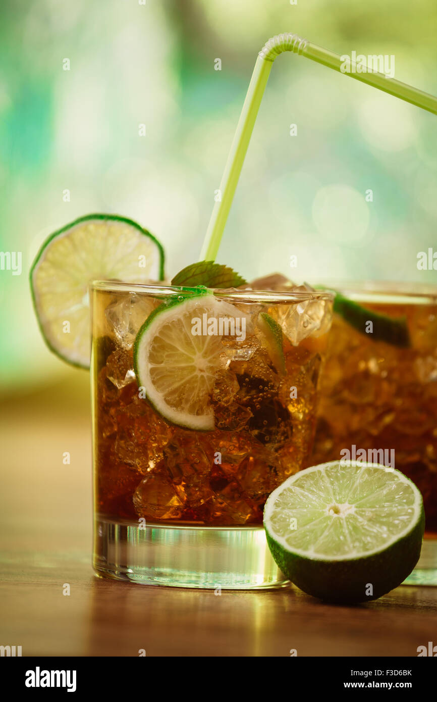 drink concept - cocktail with cola ice cubes and lime Stock Photo - Alamy