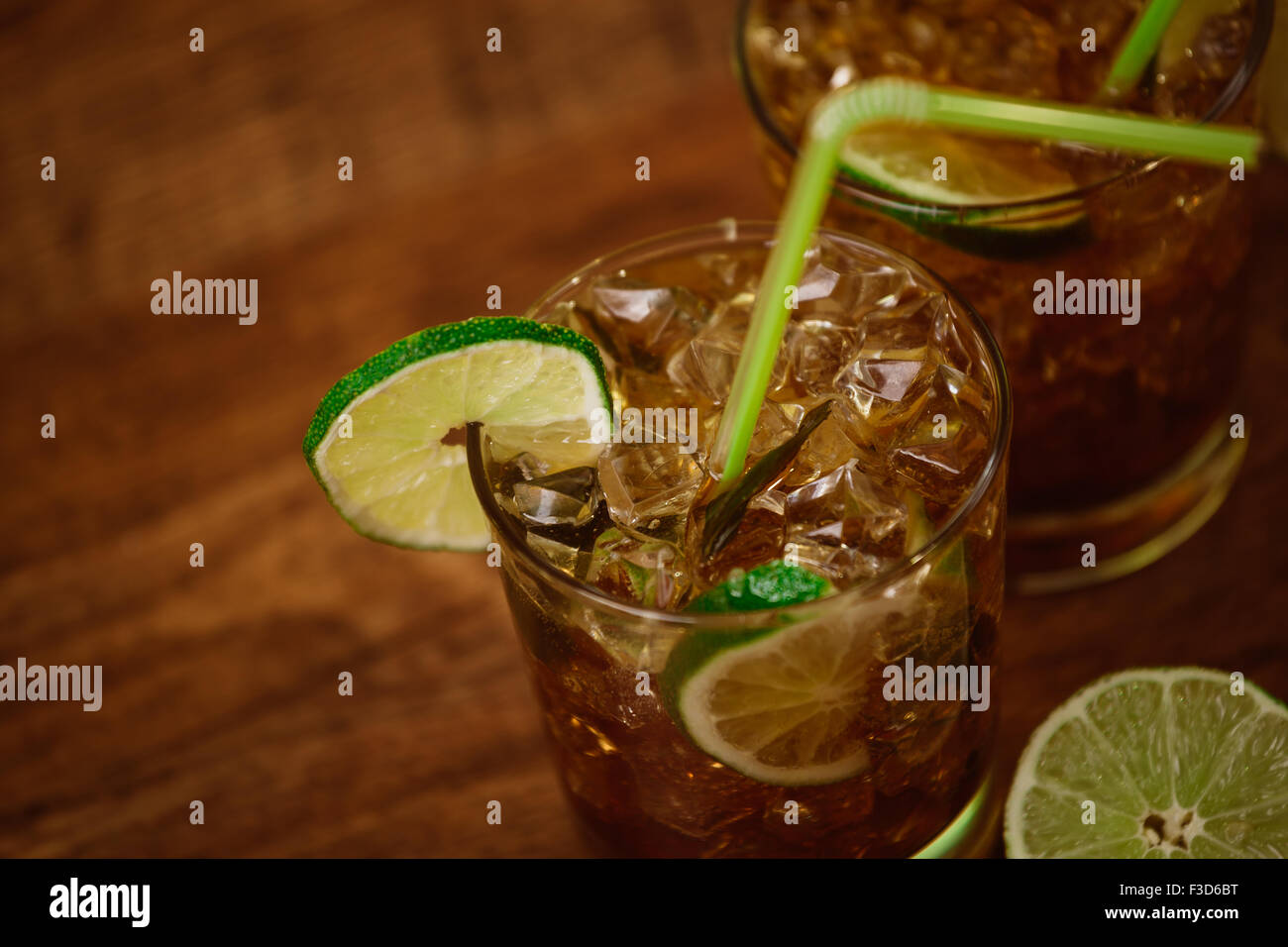 drink concept - cocktail with cola ice cubes and lime Stock Photo - Alamy