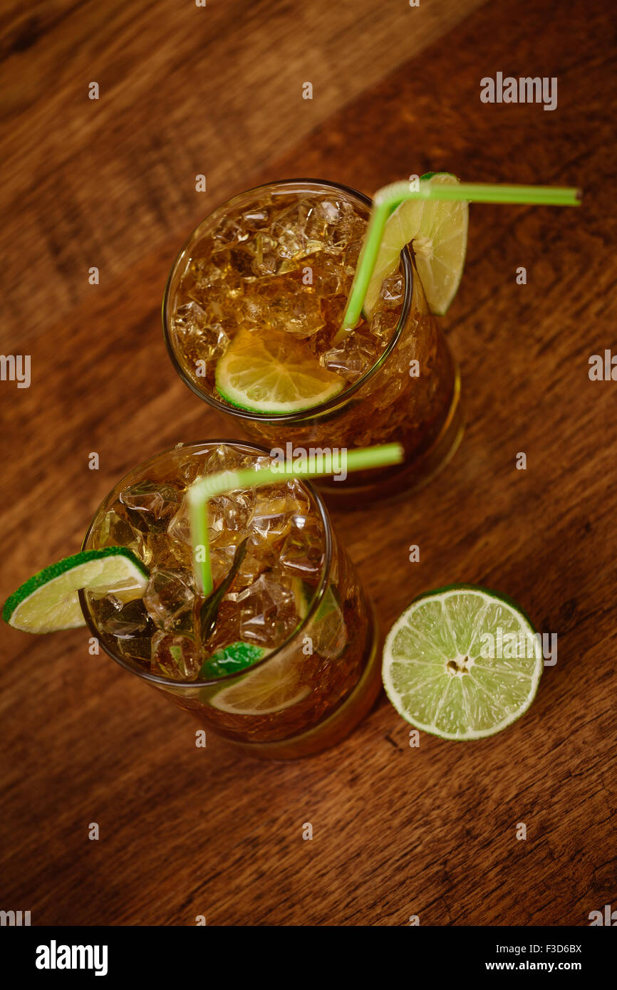 drink concept - cocktail with cola ice cubes and lime Stock Photo - Alamy