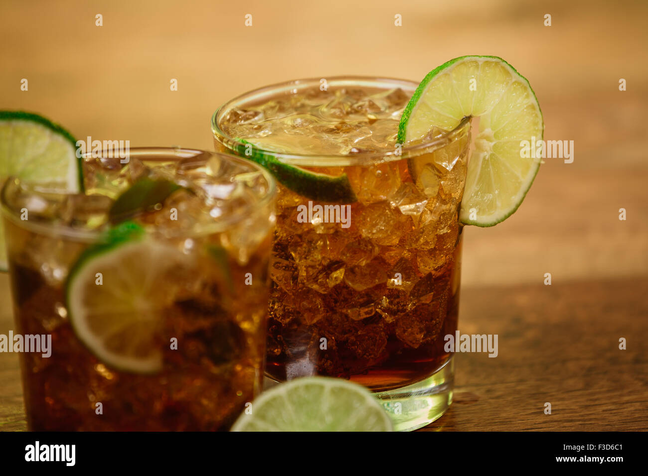 drink concept - cocktail with cola ice cubes and lime Stock Photo - Alamy