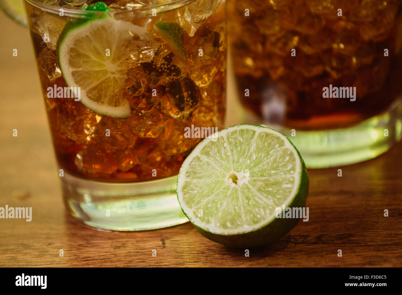 drink concept - cocktail with cola ice cubes and lime Stock Photo - Alamy