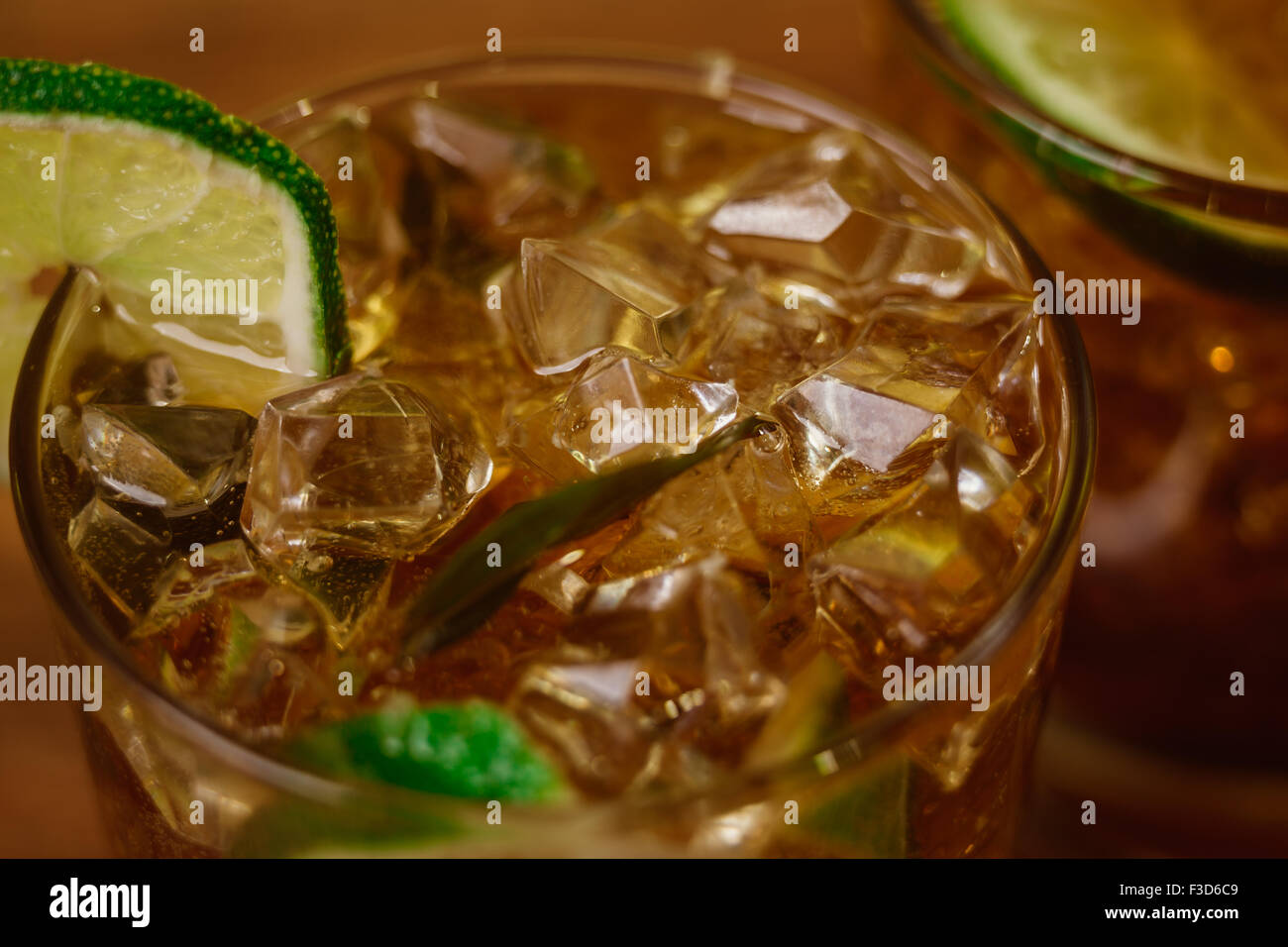 drink concept - cocktail with cola ice cubes and lime Stock Photo - Alamy