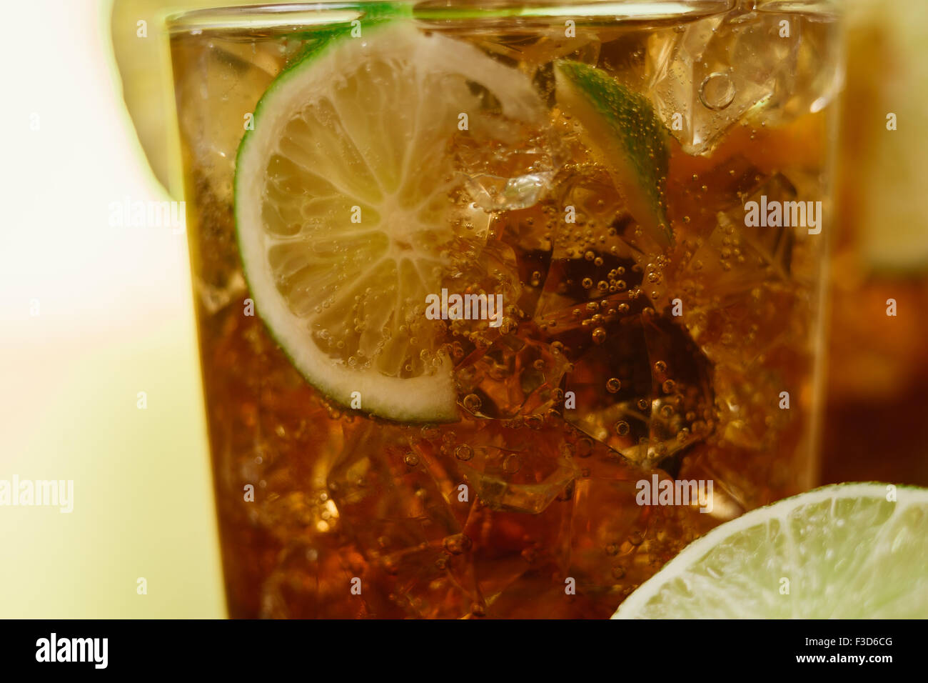 drink concept - cocktail with cola ice cubes and lime Stock Photo - Alamy