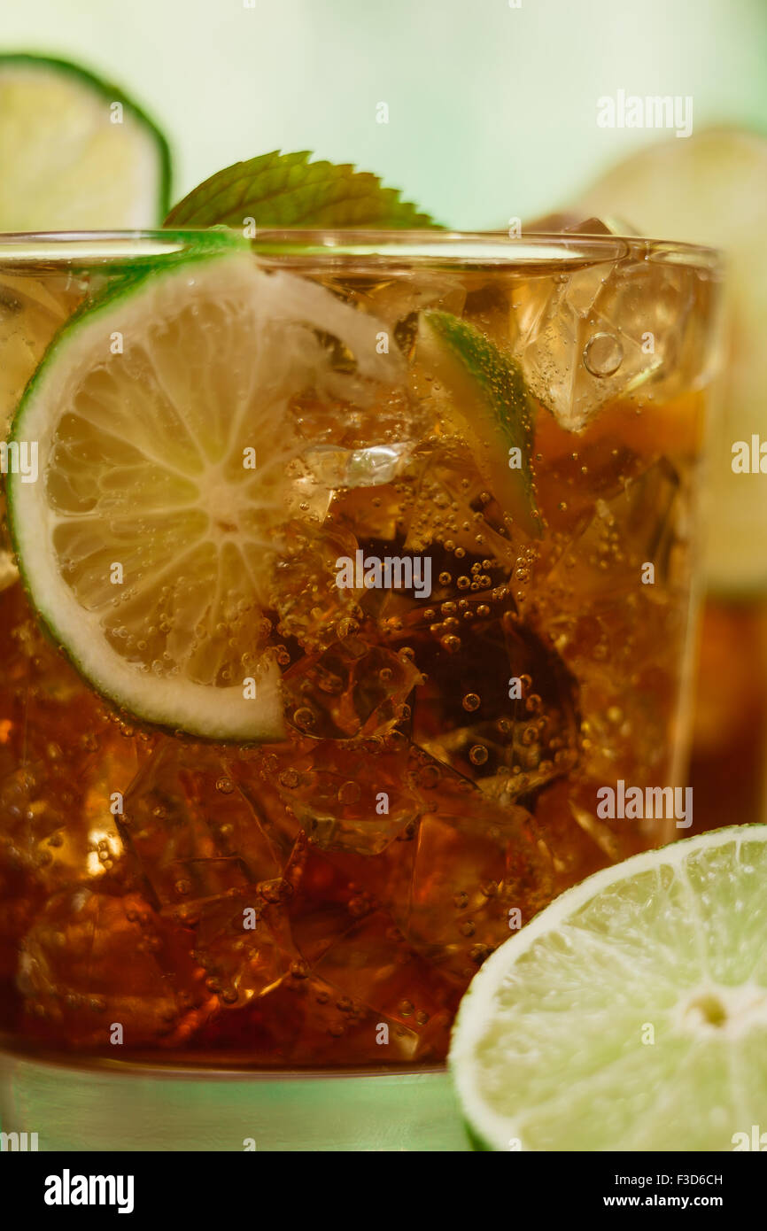 drink concept - cocktail with cola ice cubes and lime Stock Photo - Alamy