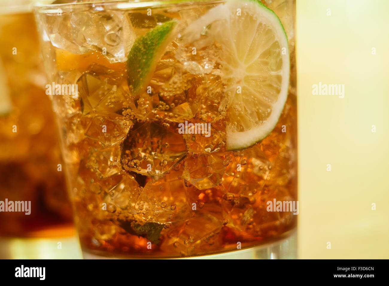 drink concept - cocktail with cola ice cubes and lime Stock Photo - Alamy