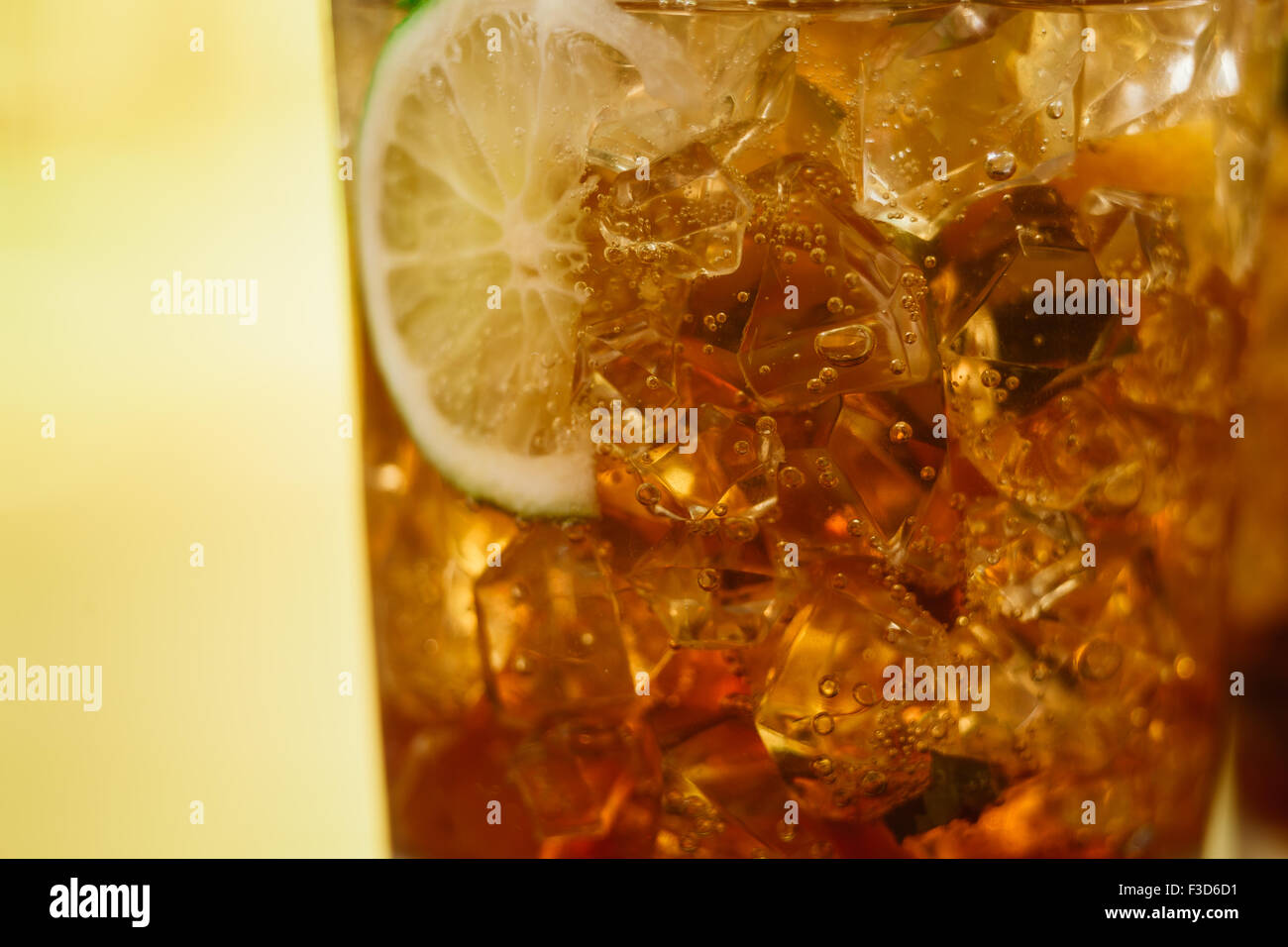 drink concept - cocktail with cola ice cubes and lime Stock Photo - Alamy