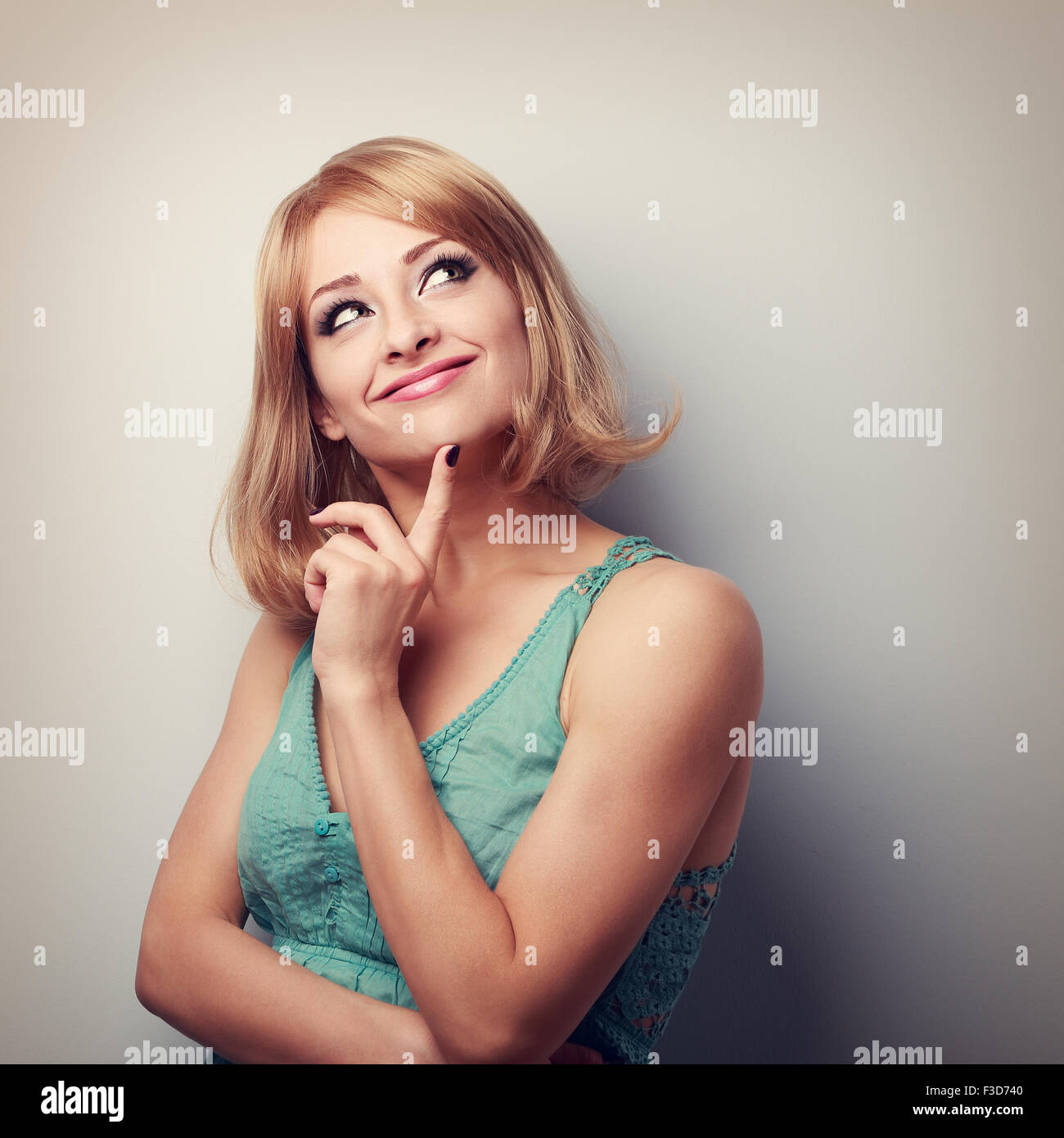 Cute thinking happy woman looking up with natural emotion and casual ...