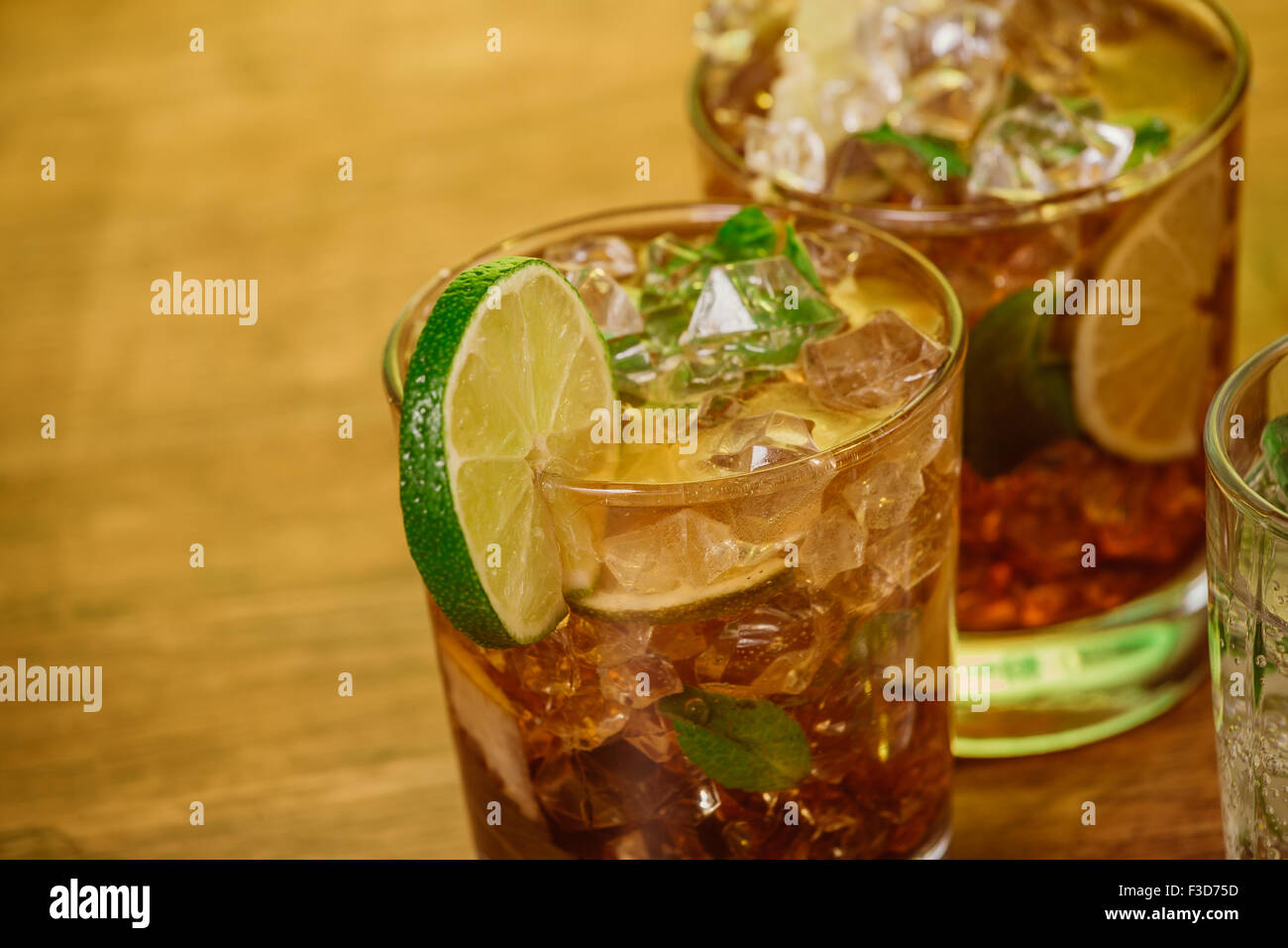 drink concept - cocktail with cola ice cubes and lime Stock Photo - Alamy