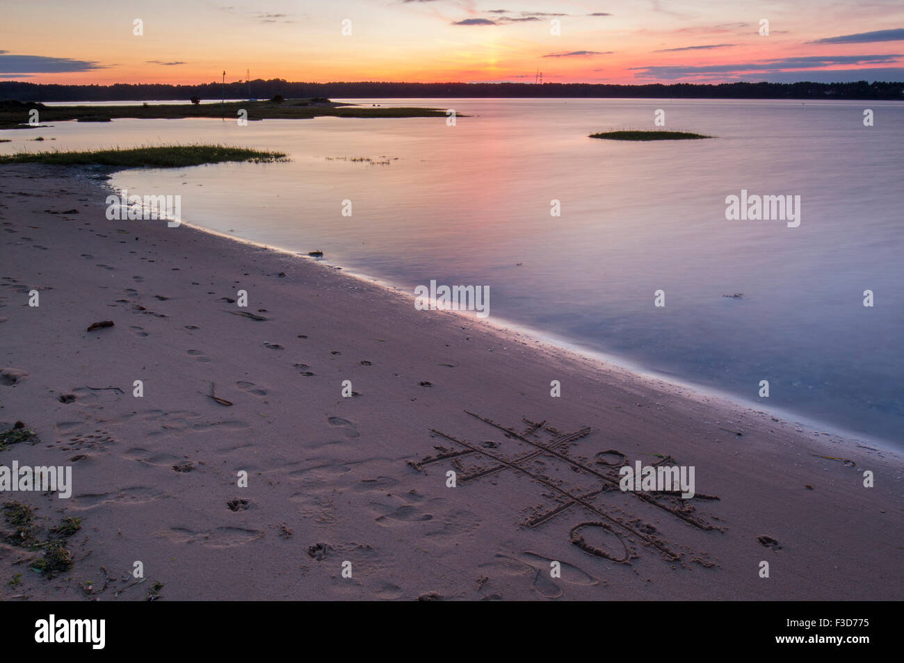 sunset entertainment playing noughts & crosses in sand Stock Photo - Alamy