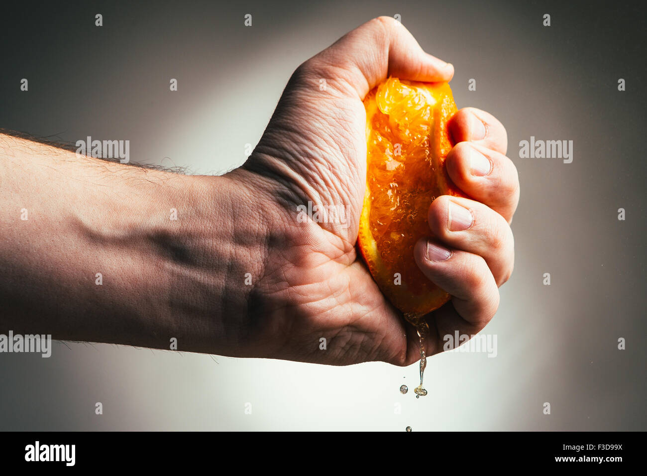 man dramatic squeezes orange. Concept squeezed a man is tired from work ...