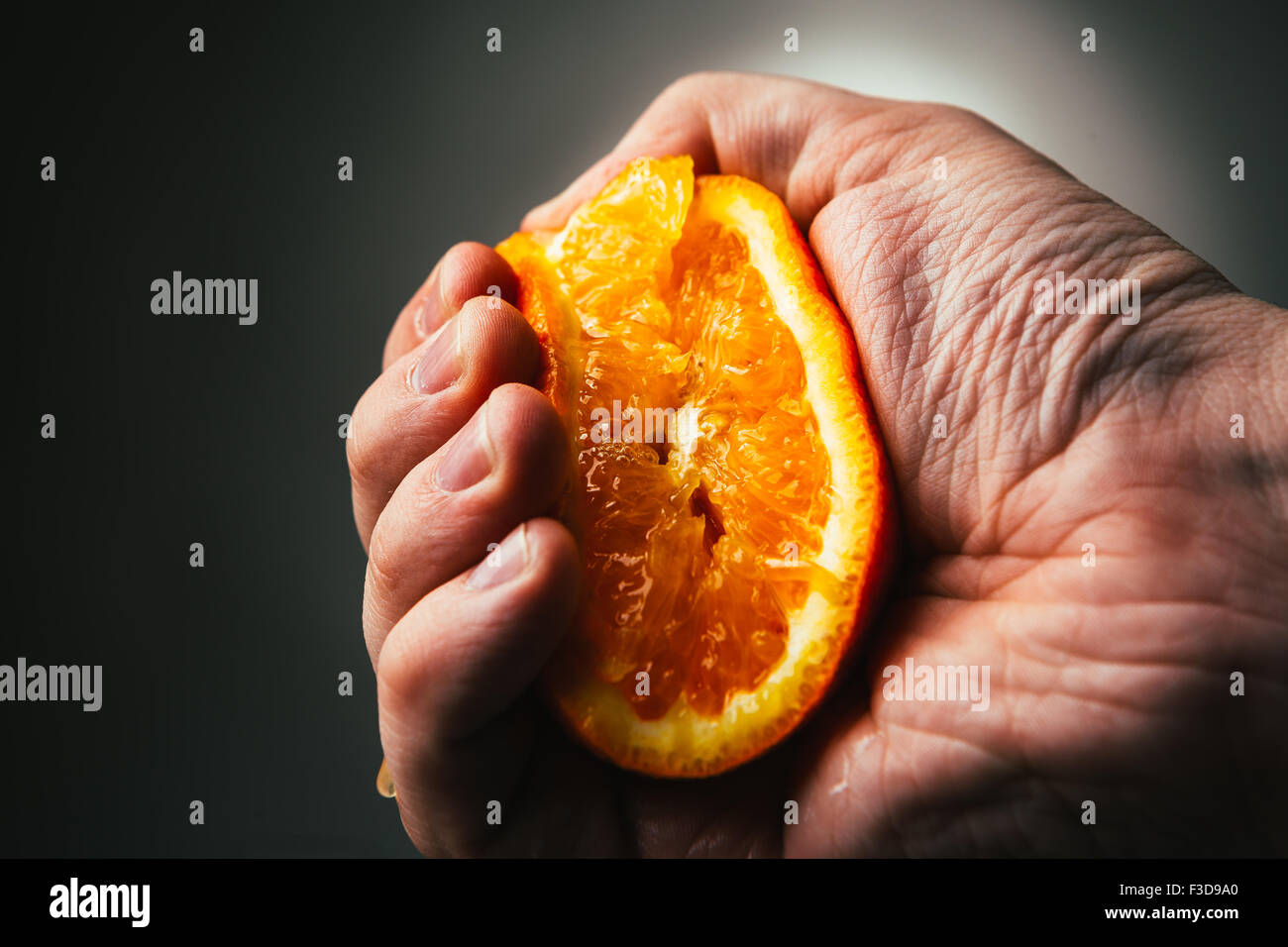 man dramatic squeezes orange. Concept squeezed a man is tired from work ...