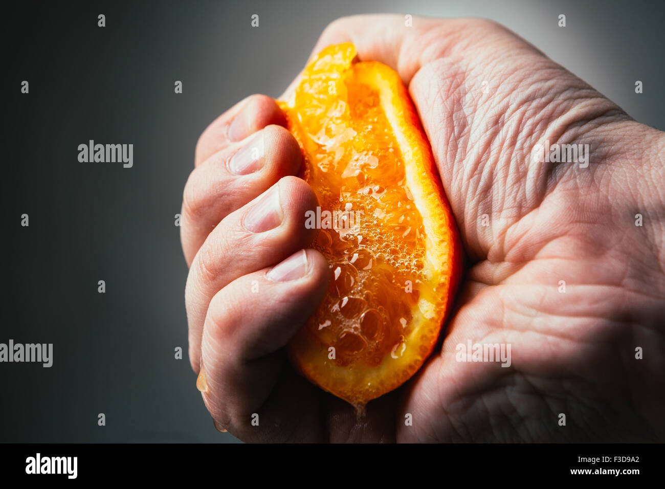 man dramatic squeezes orange. Concept squeezed a man is tired from work ...