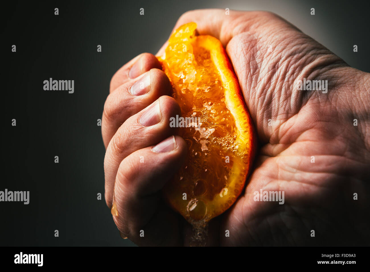 man dramatic squeezes orange. Concept squeezed a man is tired from work ...